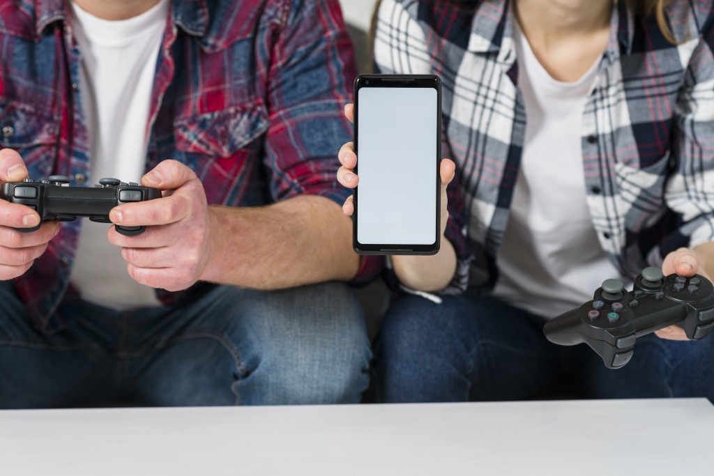 mid-section-young-couple-playing-video-game-showing-smart-phone-with ...